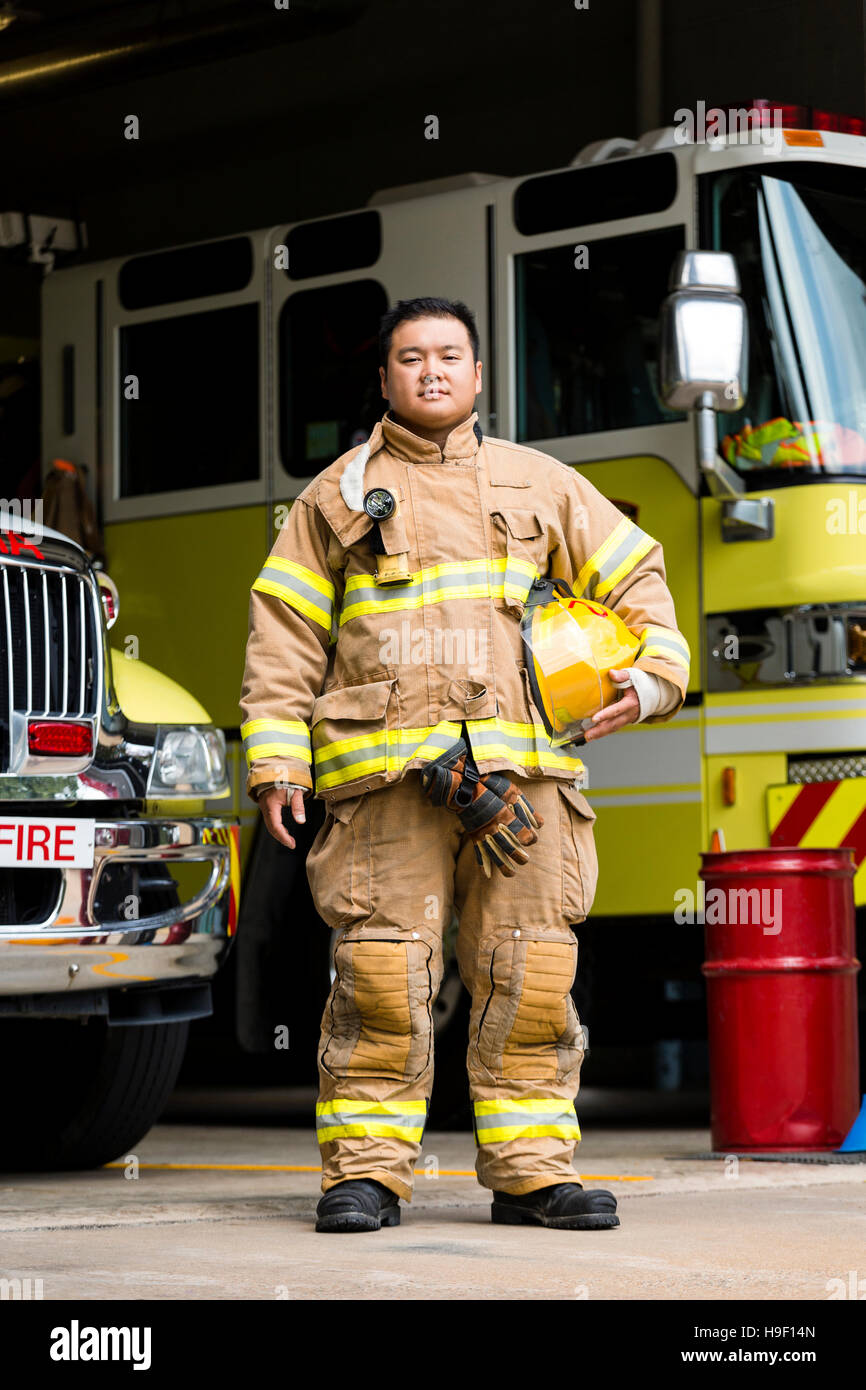 Serious Chinese fireman posing near fire trucks Stock Photo - Alamy