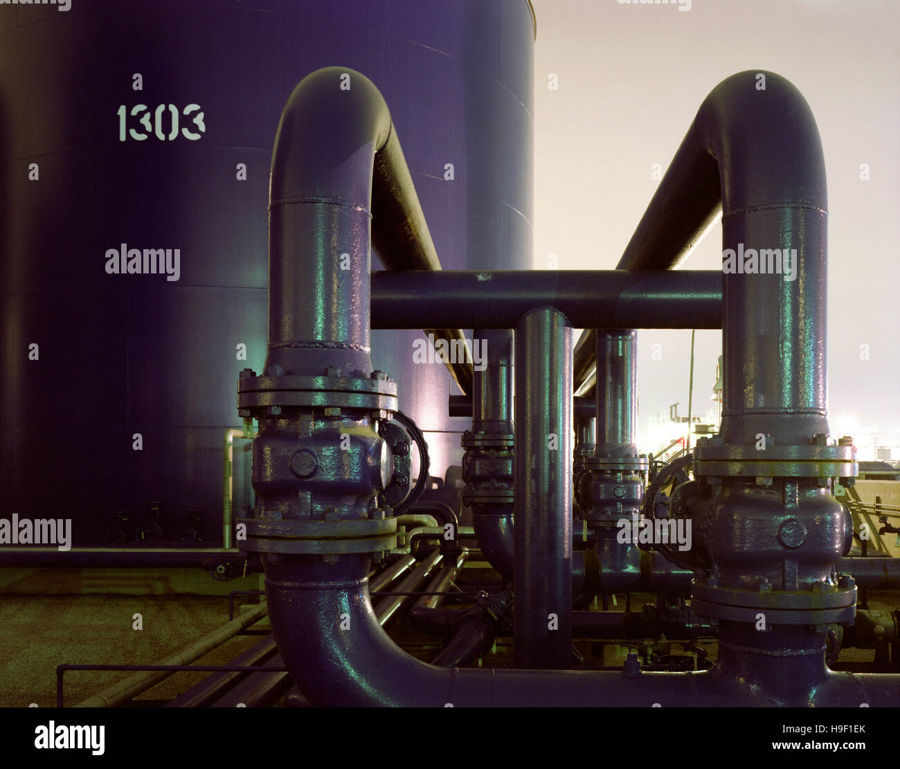 Blue industrial pipes and storage tank at sunset Stock Photo - Alamy