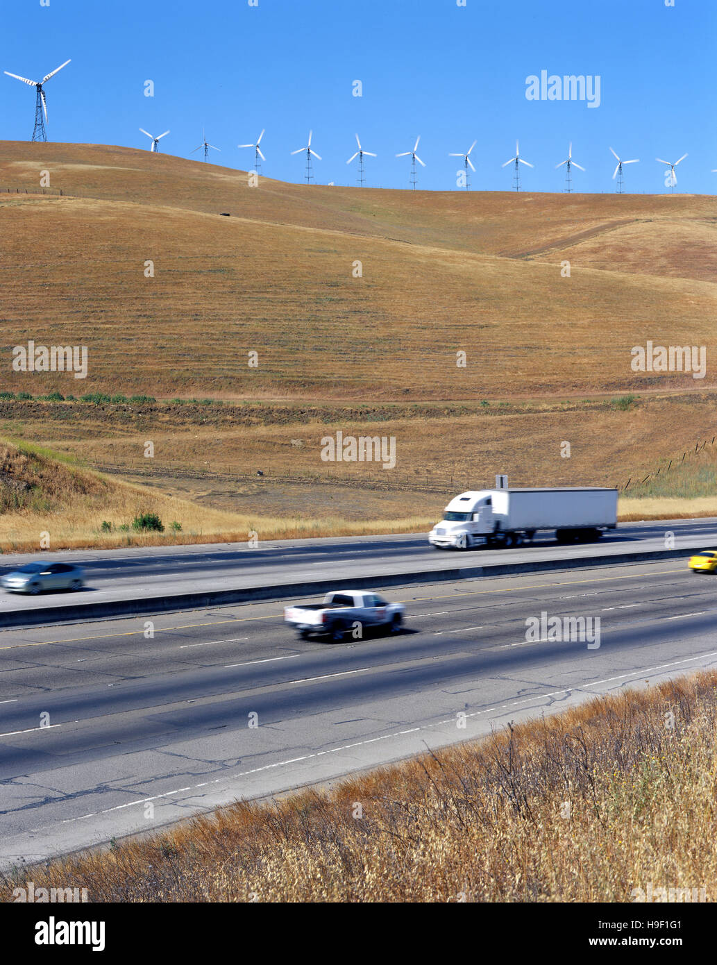 Cars and trucks driving on freeway near wind farm Stock Photo - Alamy
