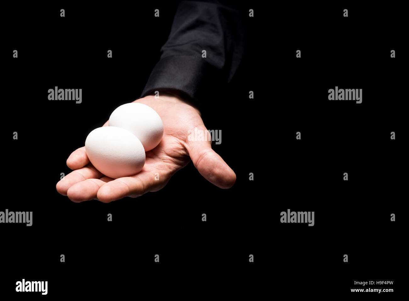 Close up of mans hand holding two eggs Stock Photo - Alamy