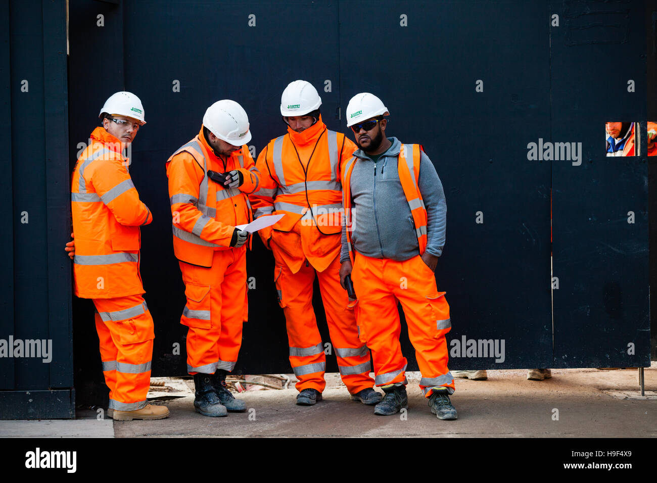 Groundsmen construction site workers in high visibility jackets on a ...
