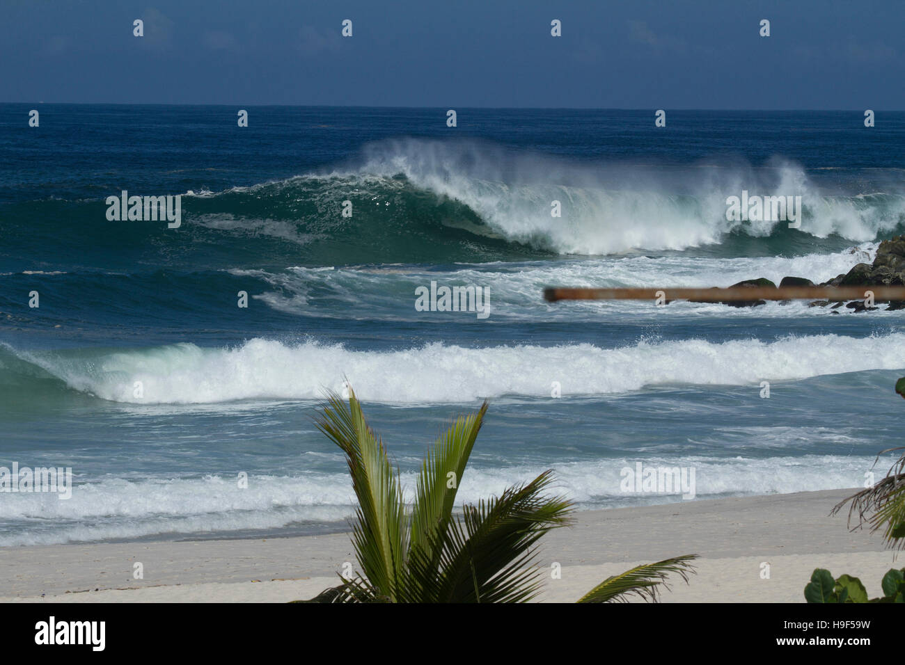 Perfect waves breaking behind rocks Stock Photo - Alamy