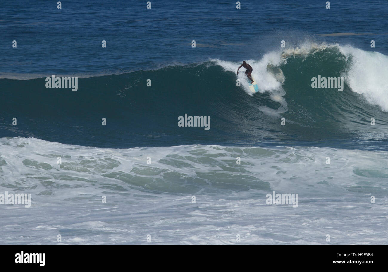 Surfer beginning to ride a long wave Stock Photo - Alamy