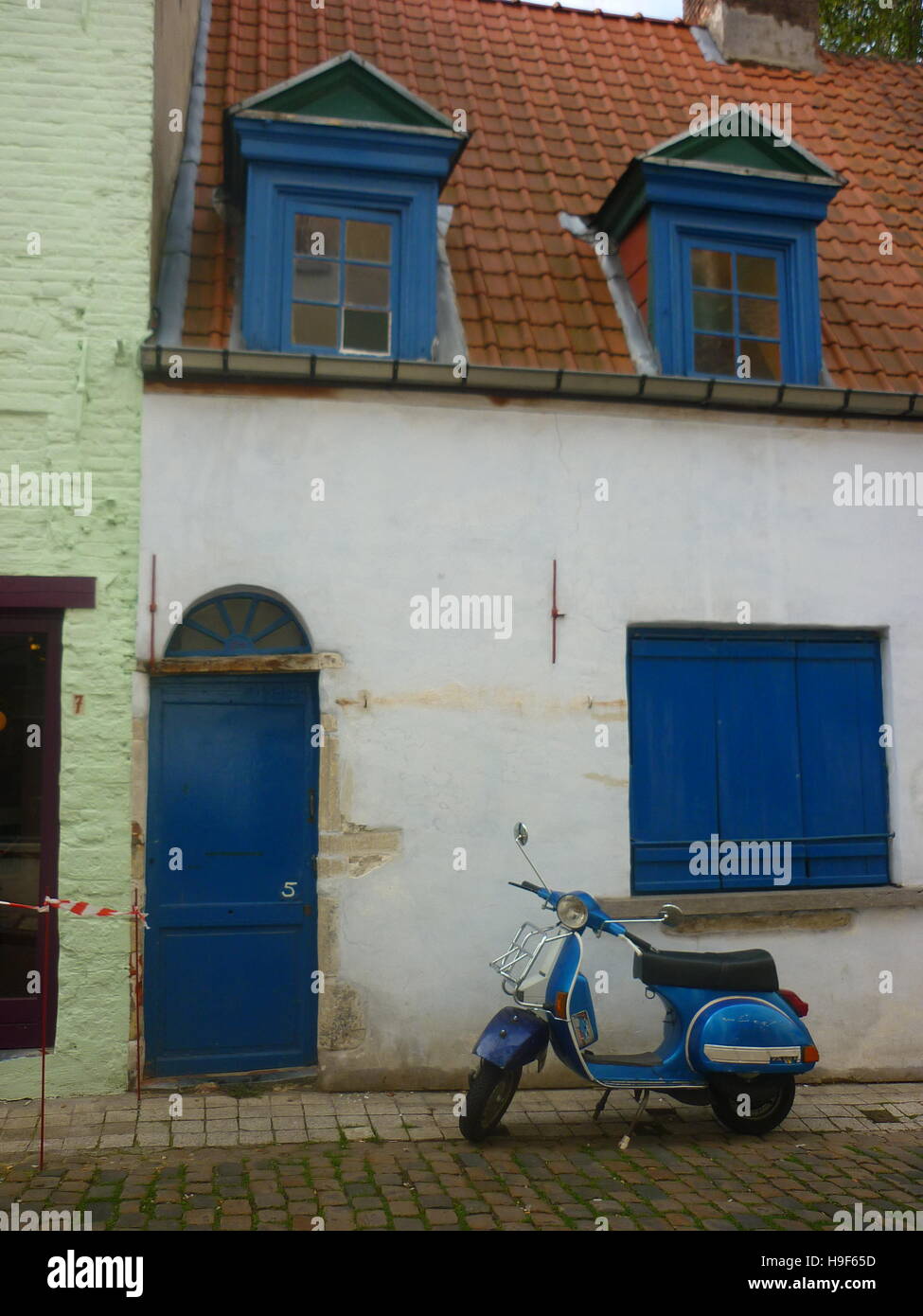 A Vespa motorcycle parked outside a house Stock Photo - Alamy