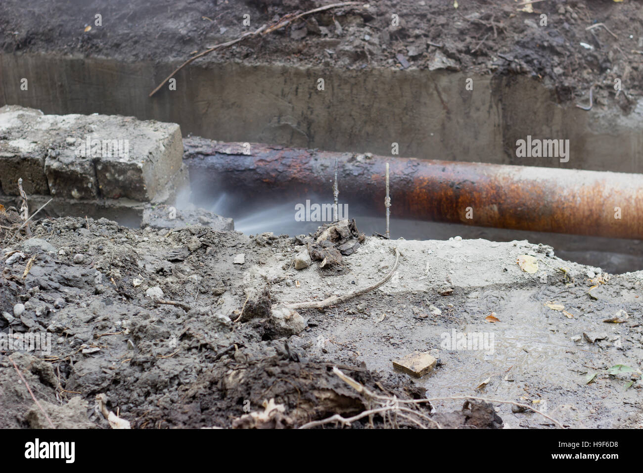 Broken old pipes of the heating system; water splashing under pressure ...