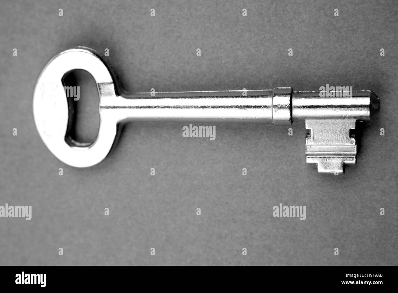 Closeup of single key on gray background Stock Photo - Alamy