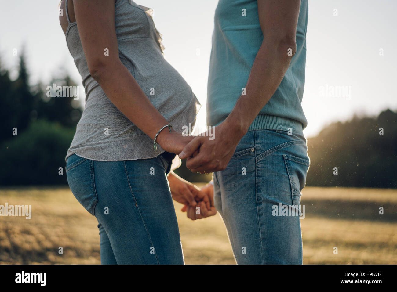 Couple expecting a child holding hands with love facing each other ...