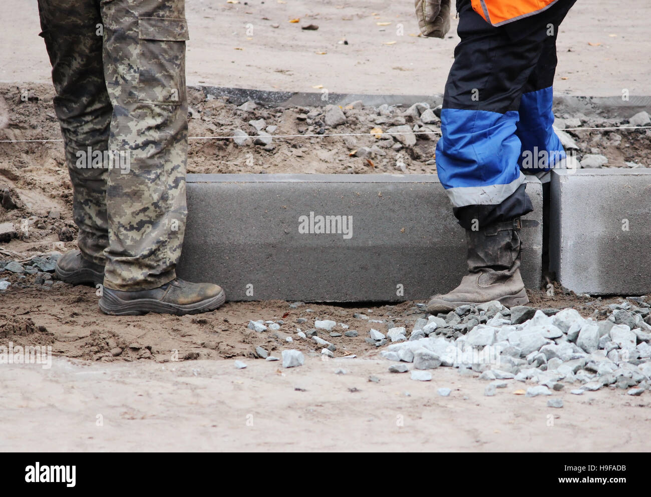 Workers are lifting concrete curb. Concrete kerb installation at ...