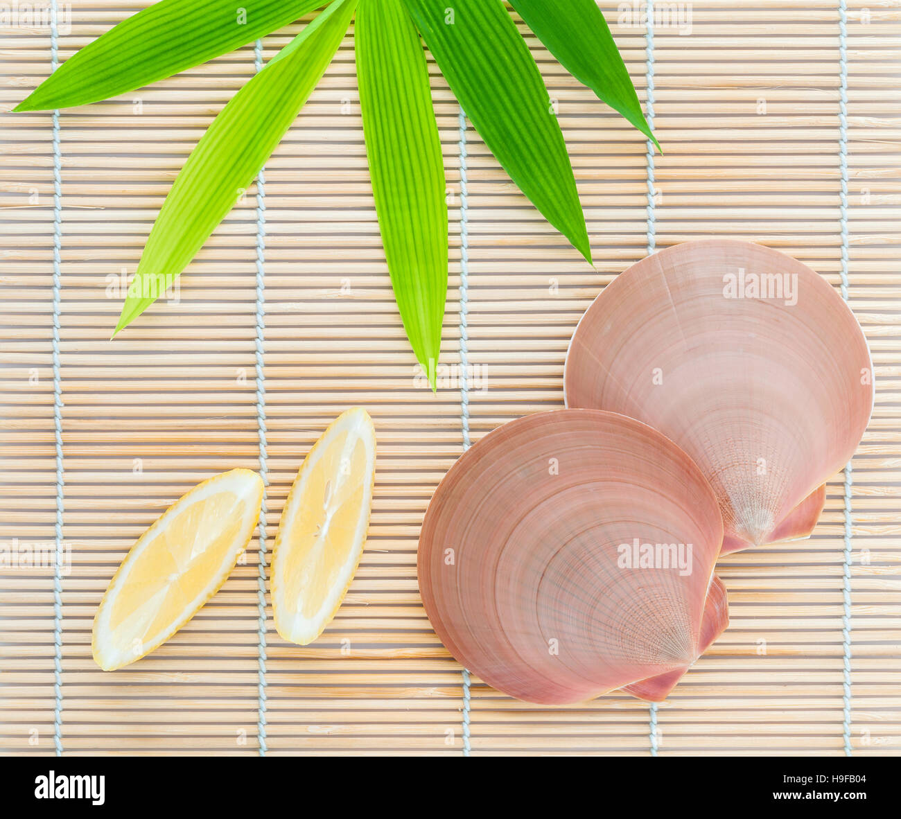 Raw queen scallops with lemon slice on bamboo background and b Stock ...