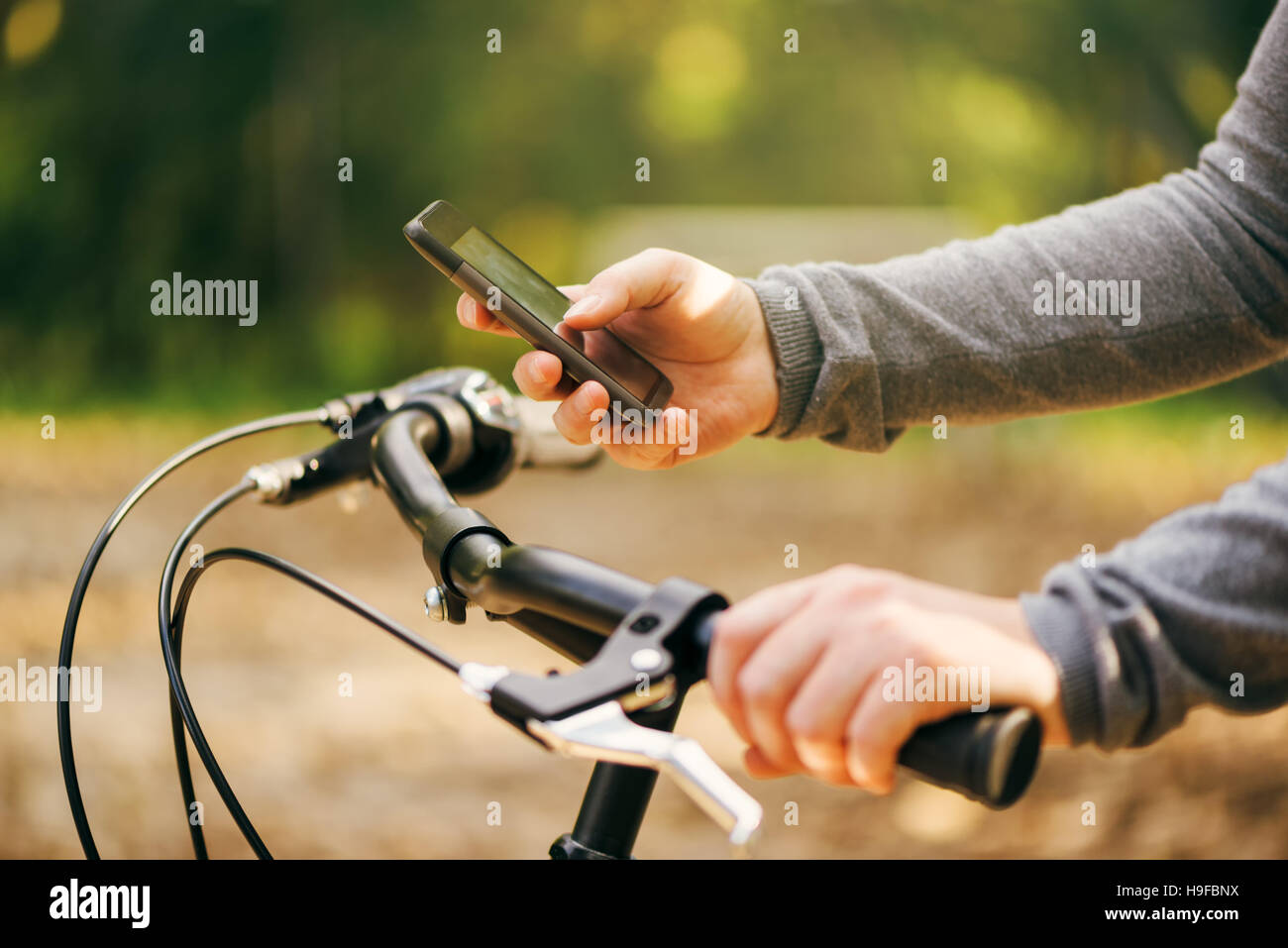 Woman typing text message during bicycle ride Stock Photo - Alamy