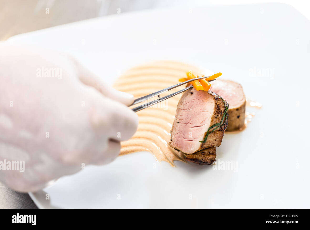 Chef garnishing meat dish Stock Photo - Alamy