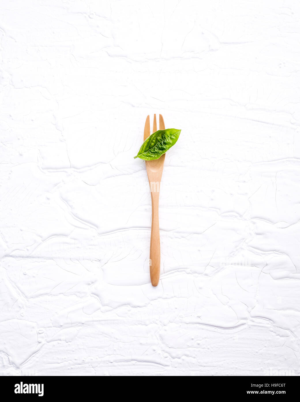 Closeup fresh sweet basil leaves with fork on white wooden bac Stock ...