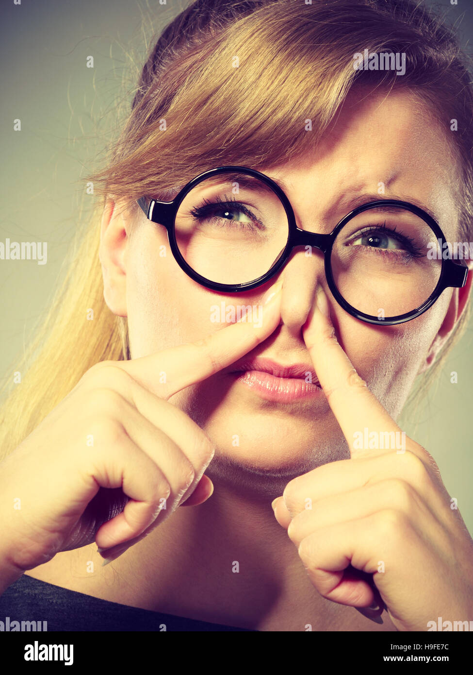 Bad smell concept. Young woman feels disgust pinches her nose with ...