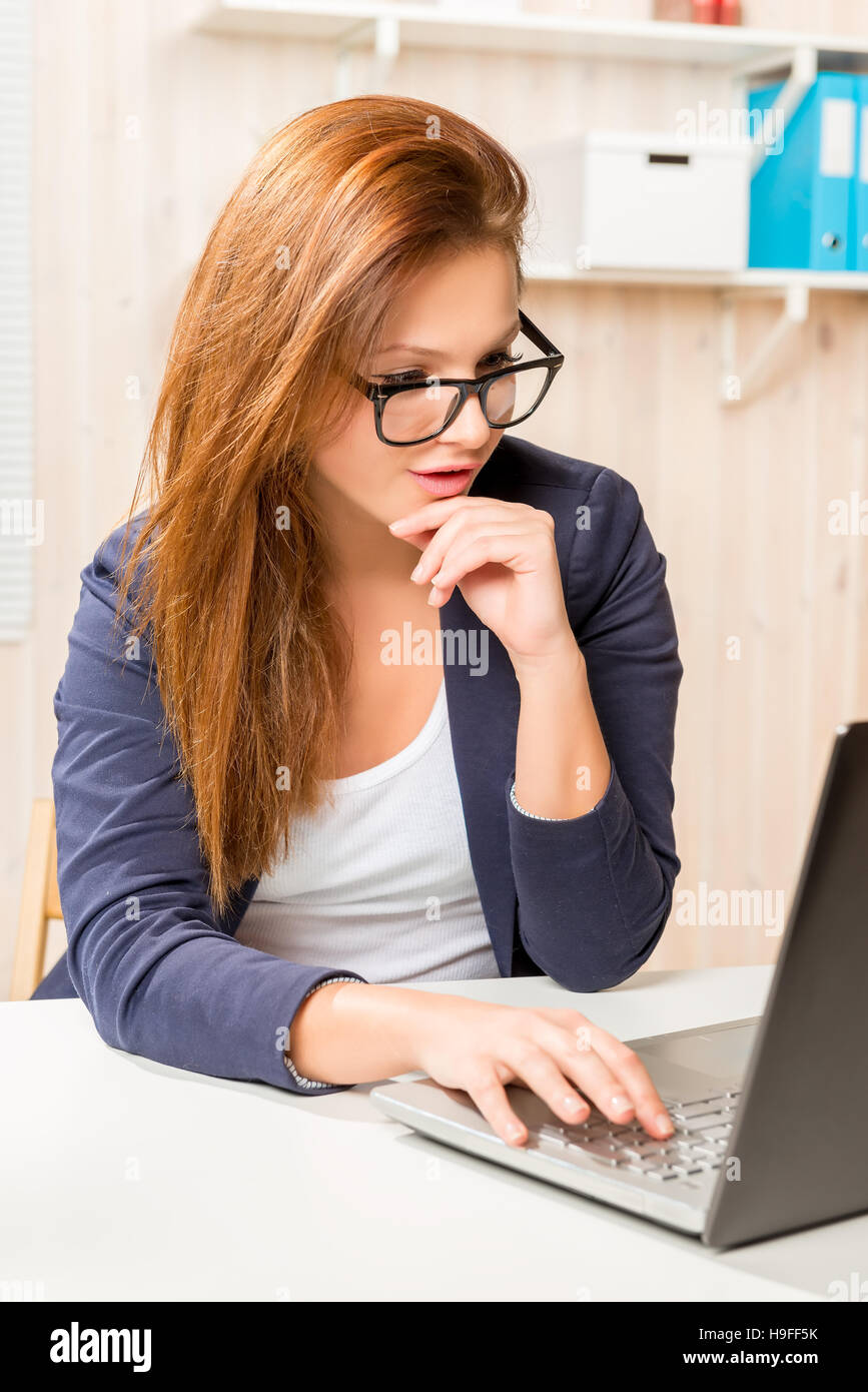 secretary with flowing hair and wearing glasses working on a lap Stock ...