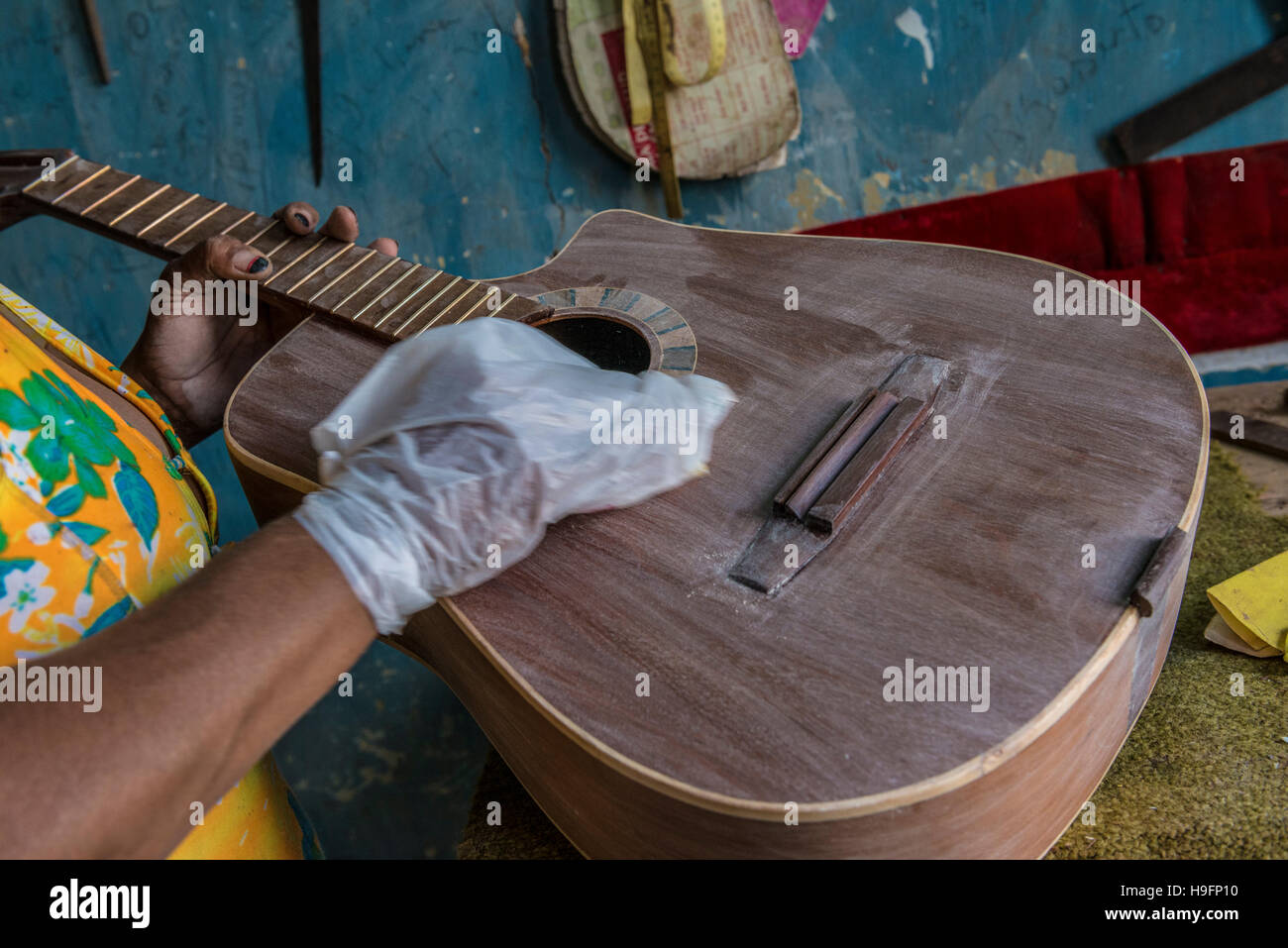 A closeup of a Cuban woman in the finishing stages of the guitar or ...