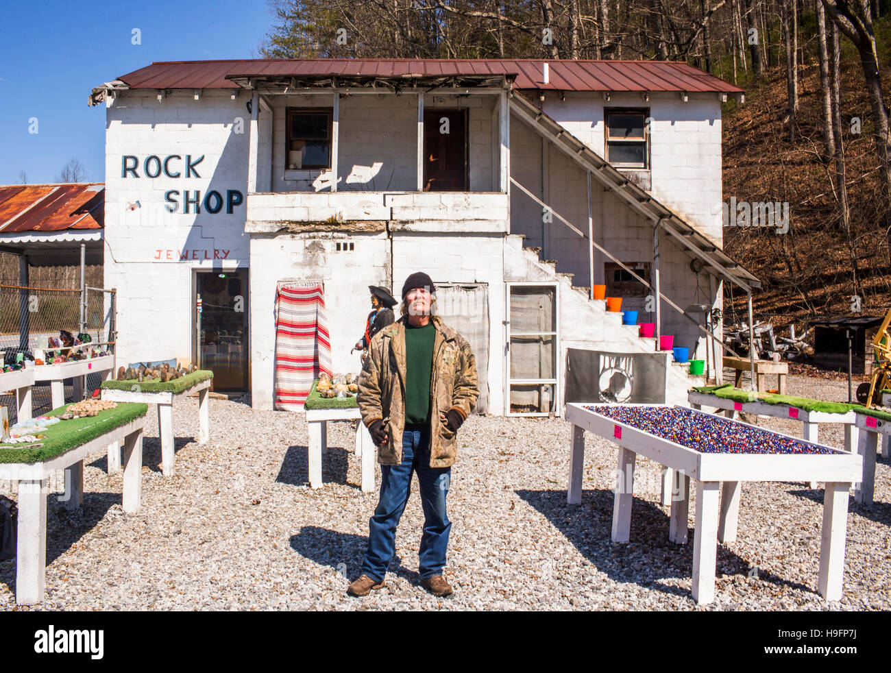 A portrait of a man selling colorful rocks and marbles at a roadside ...