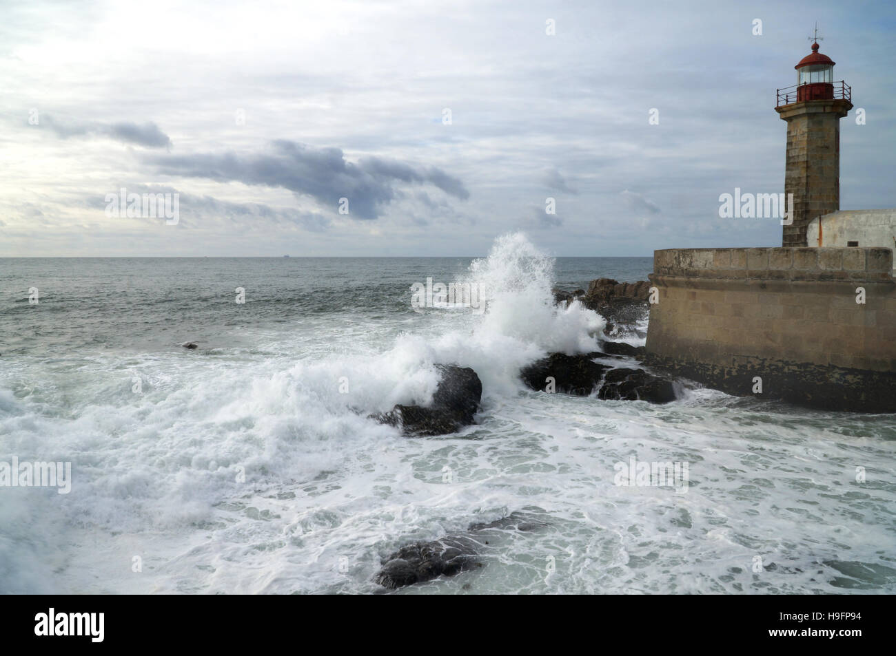 Lighthouse in Porto with wave splash at Autumn light, Porto, Portugal ...