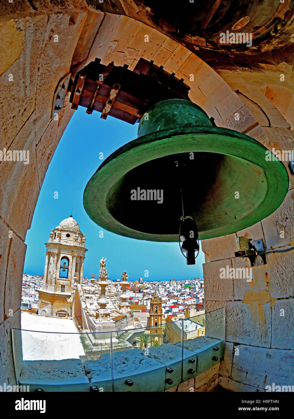 Cadiz cathedral bell tower and bell detail with white red city rooftops ...