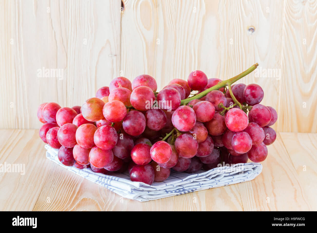 Bunch of grapes on a wooden floor Stock Photo - Alamy