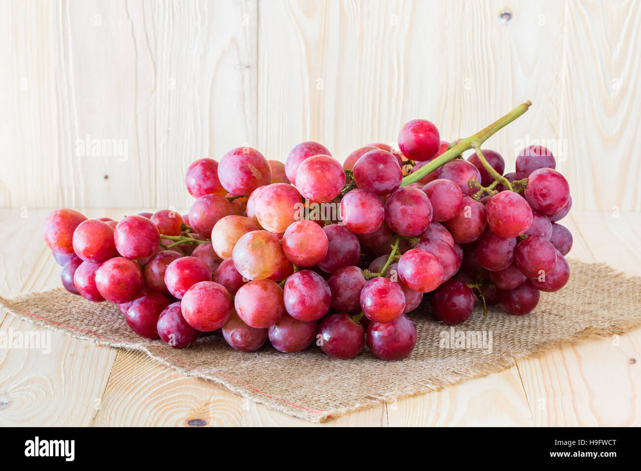 Bunch of grapes on a wooden floor Stock Photo - Alamy