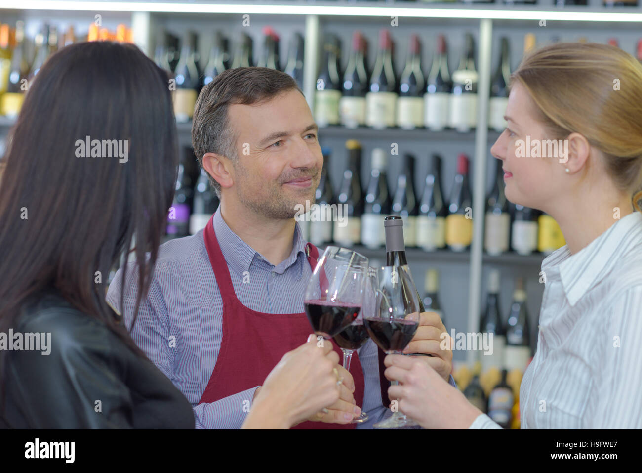 People sampling red wine in liquor store Stock Photo - Alamy