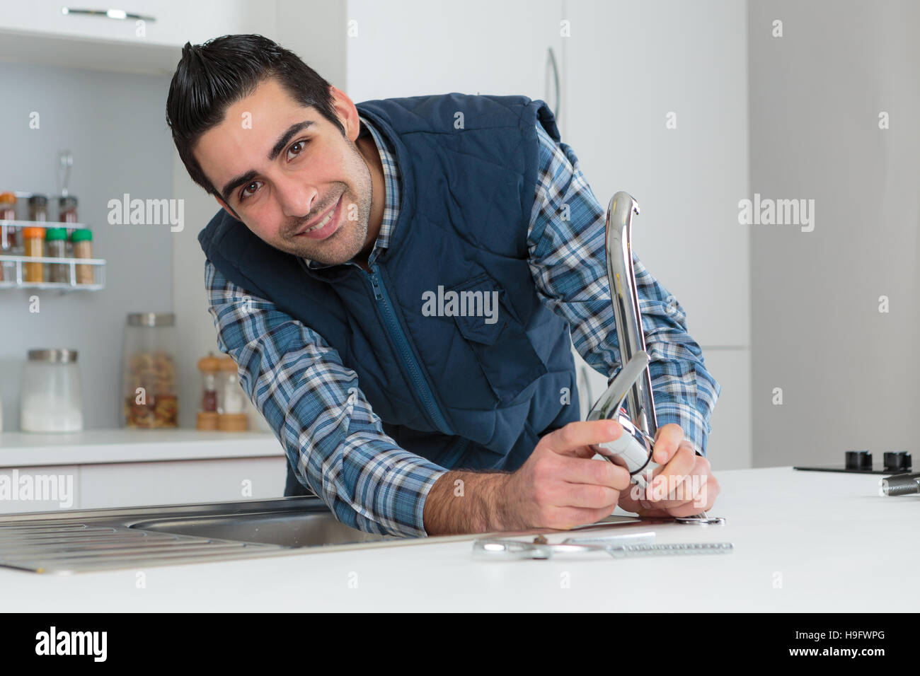 Plumber fitting kitchen sink Stock Photo - Alamy