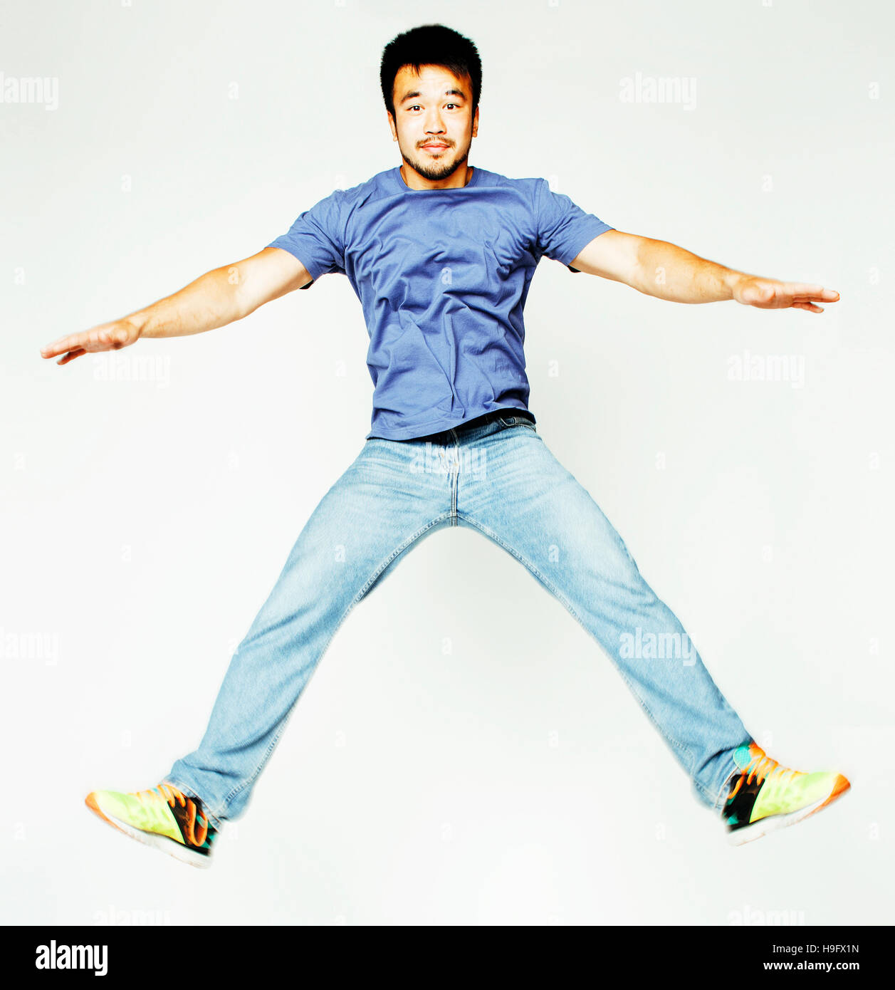 young pretty asian man jumping cheerful against white background ...