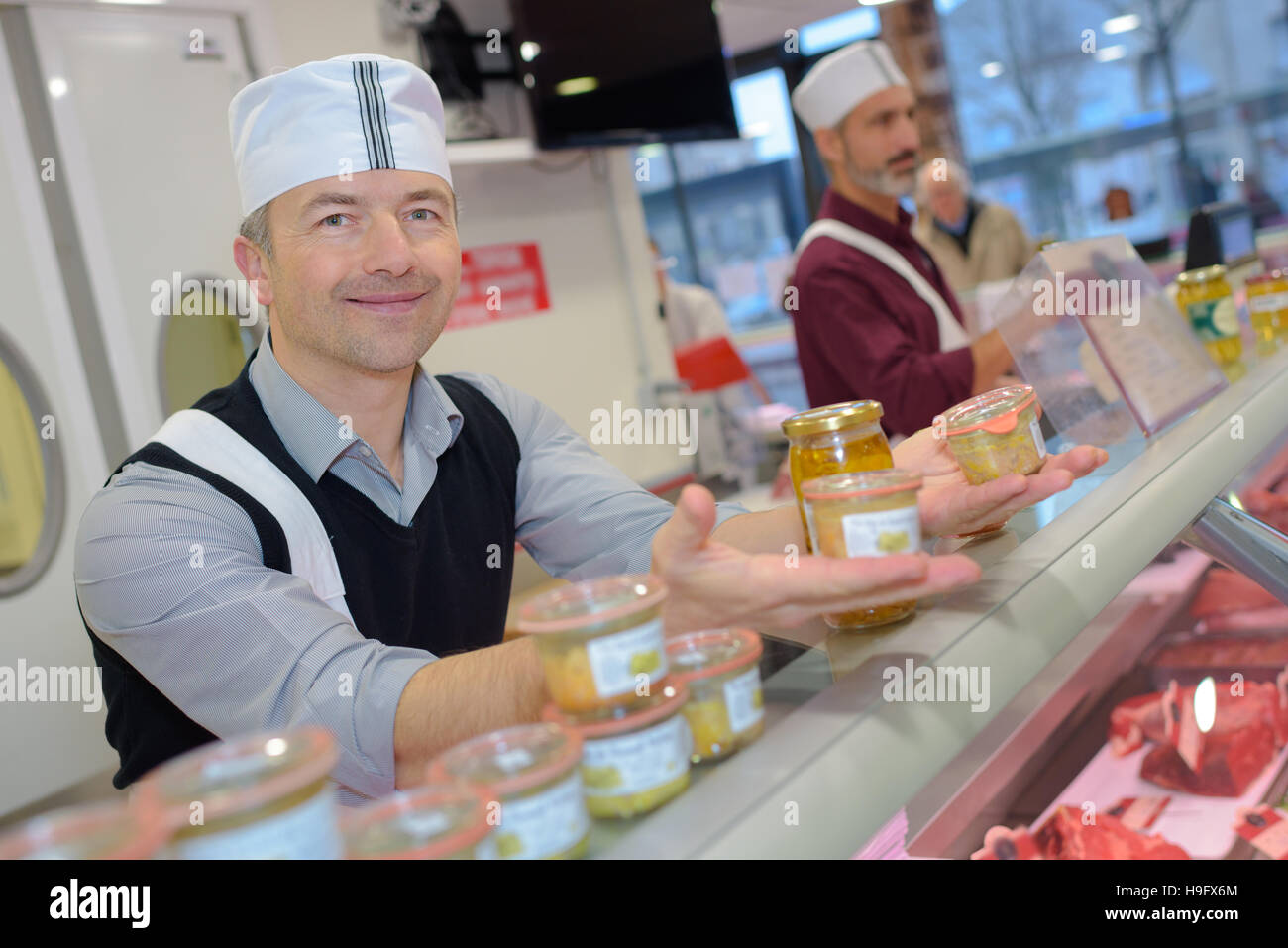 butcher serving customer in shop Stock Photo - Alamy