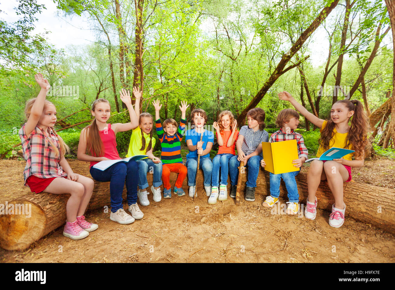 Cute kids reading books outdoor sitting on the log Stock Photo - Alamy