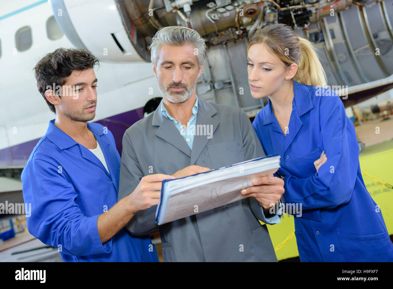 young engineer apprentices learning to repair part of airplane Stock ...