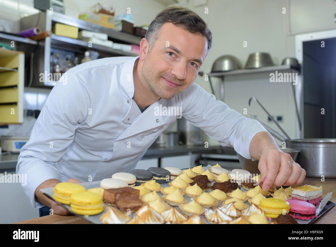 Baker holding tray of cakes Stock Photo - Alamy