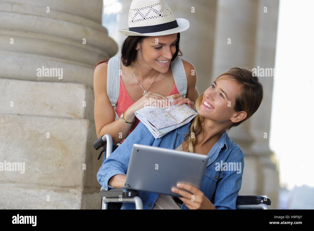 two friends visiting foreign city one sitting in wheelchair Stock Photo ...