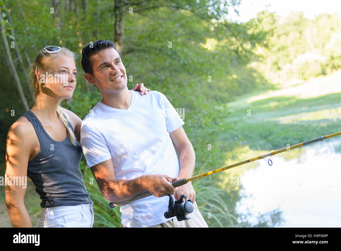 peaceful young couple fishing by the pond Stock Photo - Alamy