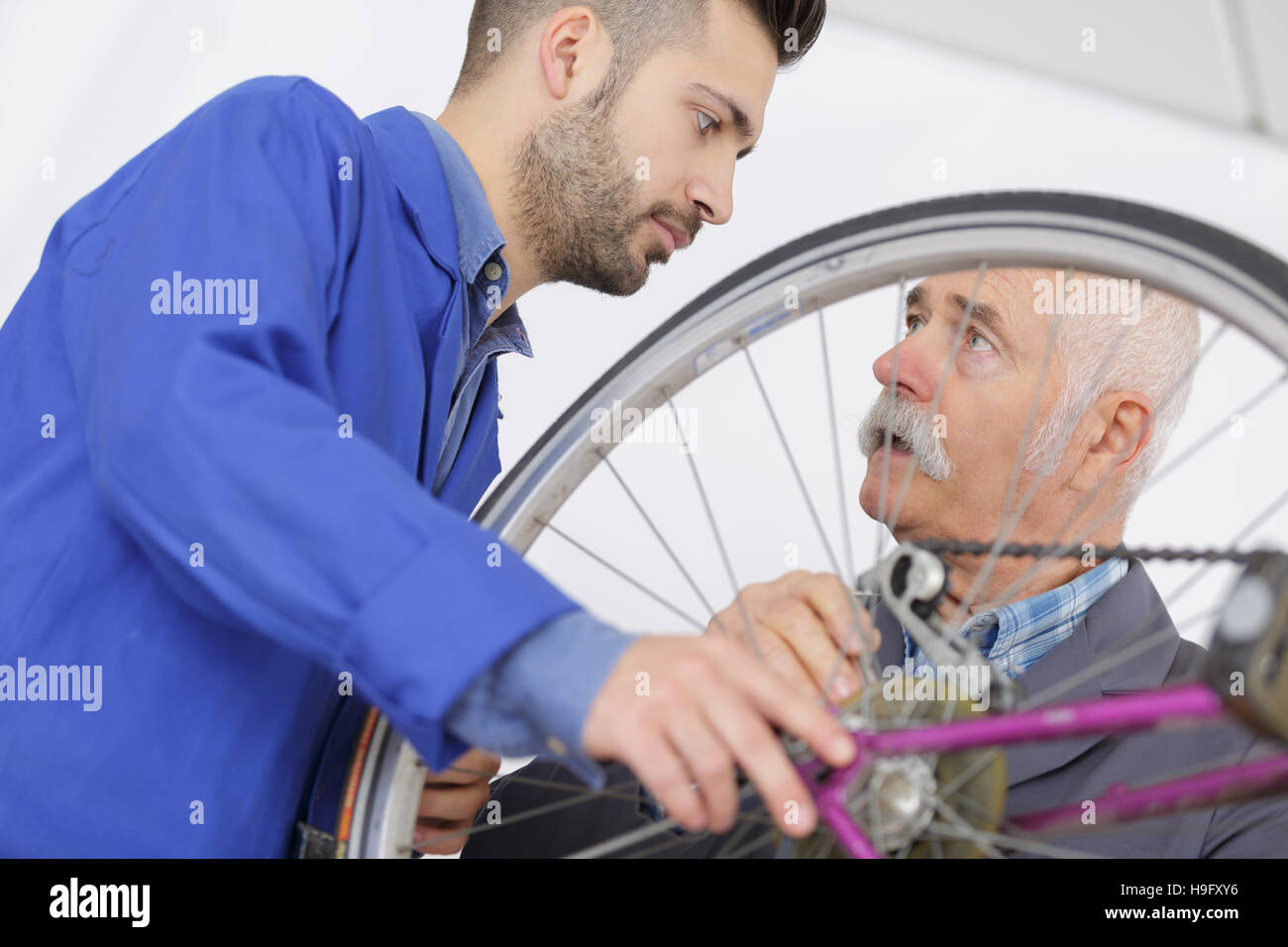 teacher with students in mechanics working on bike Stock Photo - Alamy