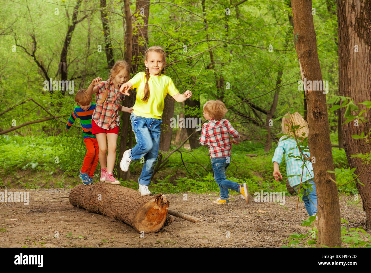 Cute little kids playing on a log in the forest Stock Photo - Alamy