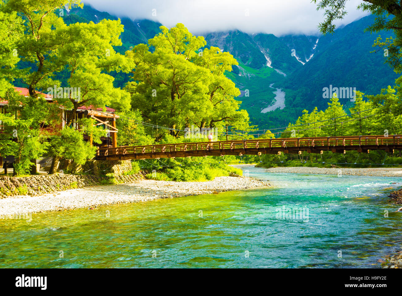 Man crossing Kappa-bashi Bridge with Mount Hotaka background during ...