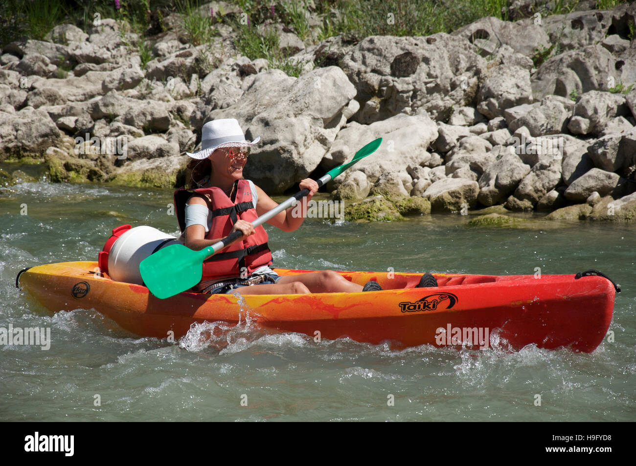 Tourism, water-sports . Young smiling woman canoeing down the rocky ...