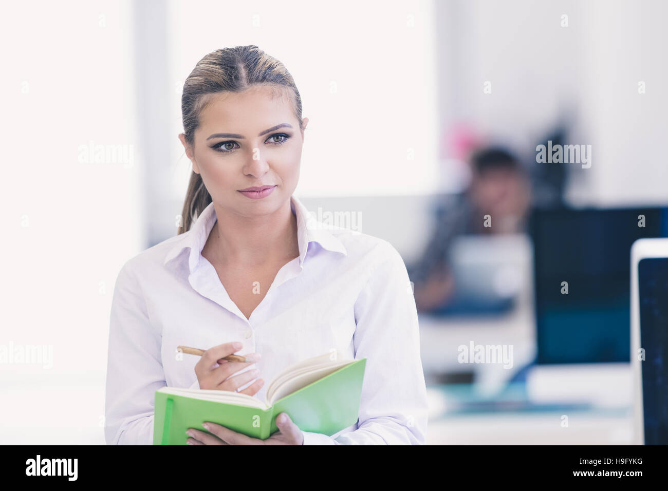Portrait of busy secretary looking at camera Stock Photo - Alamy
