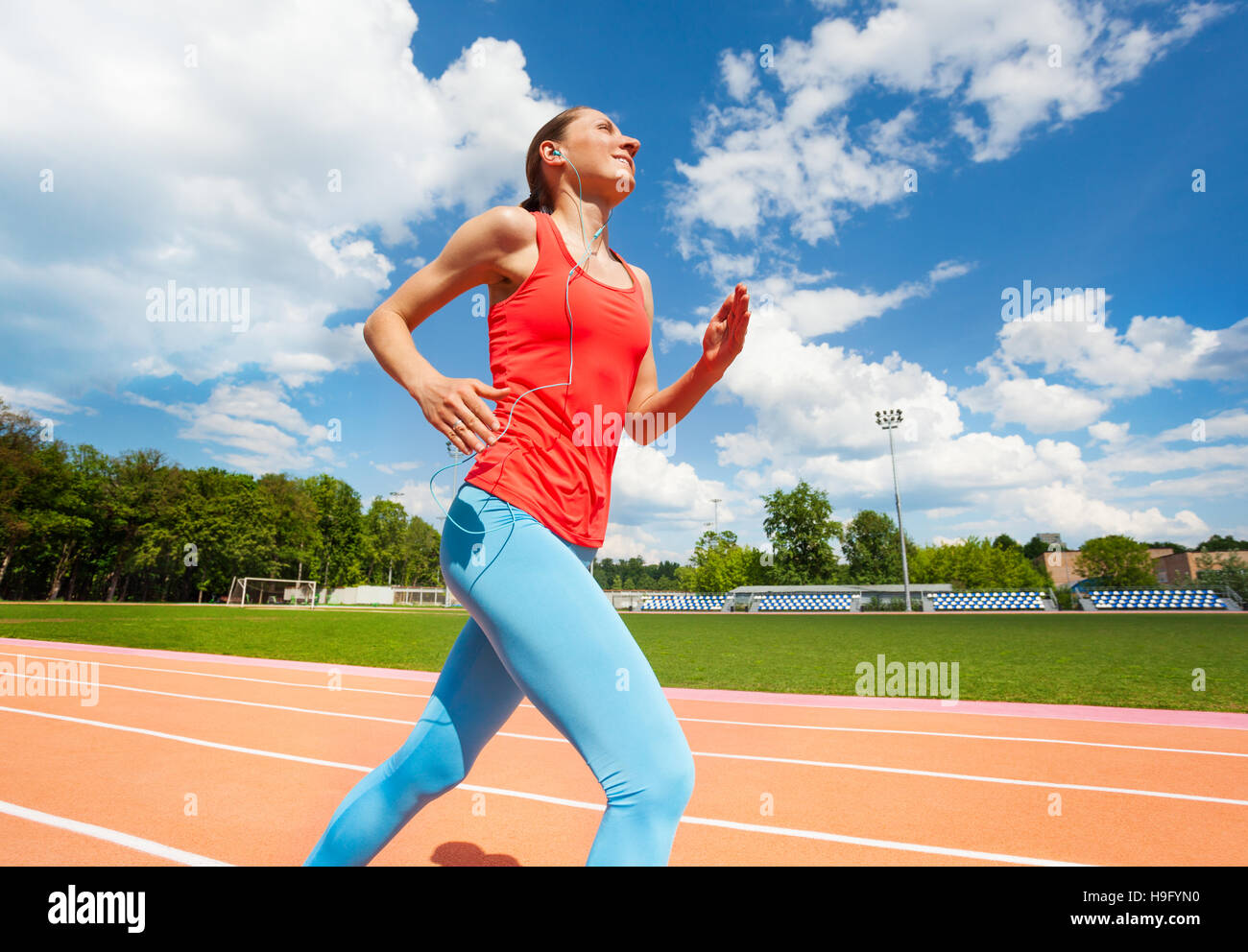 Woman listening music while running at the stadium Stock Photo - Alamy
