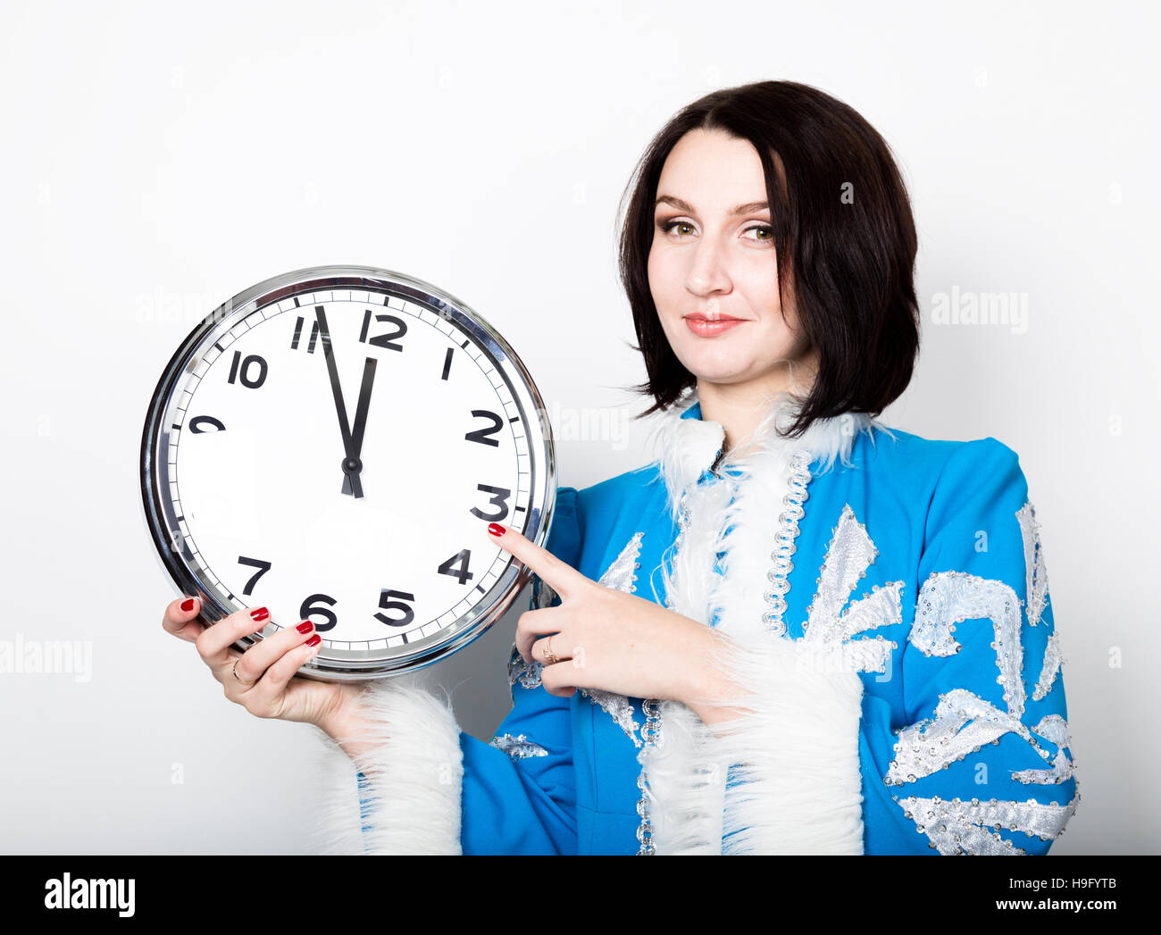 woman in christmas uniform holding a clock, pointing at clockwise Stock ...