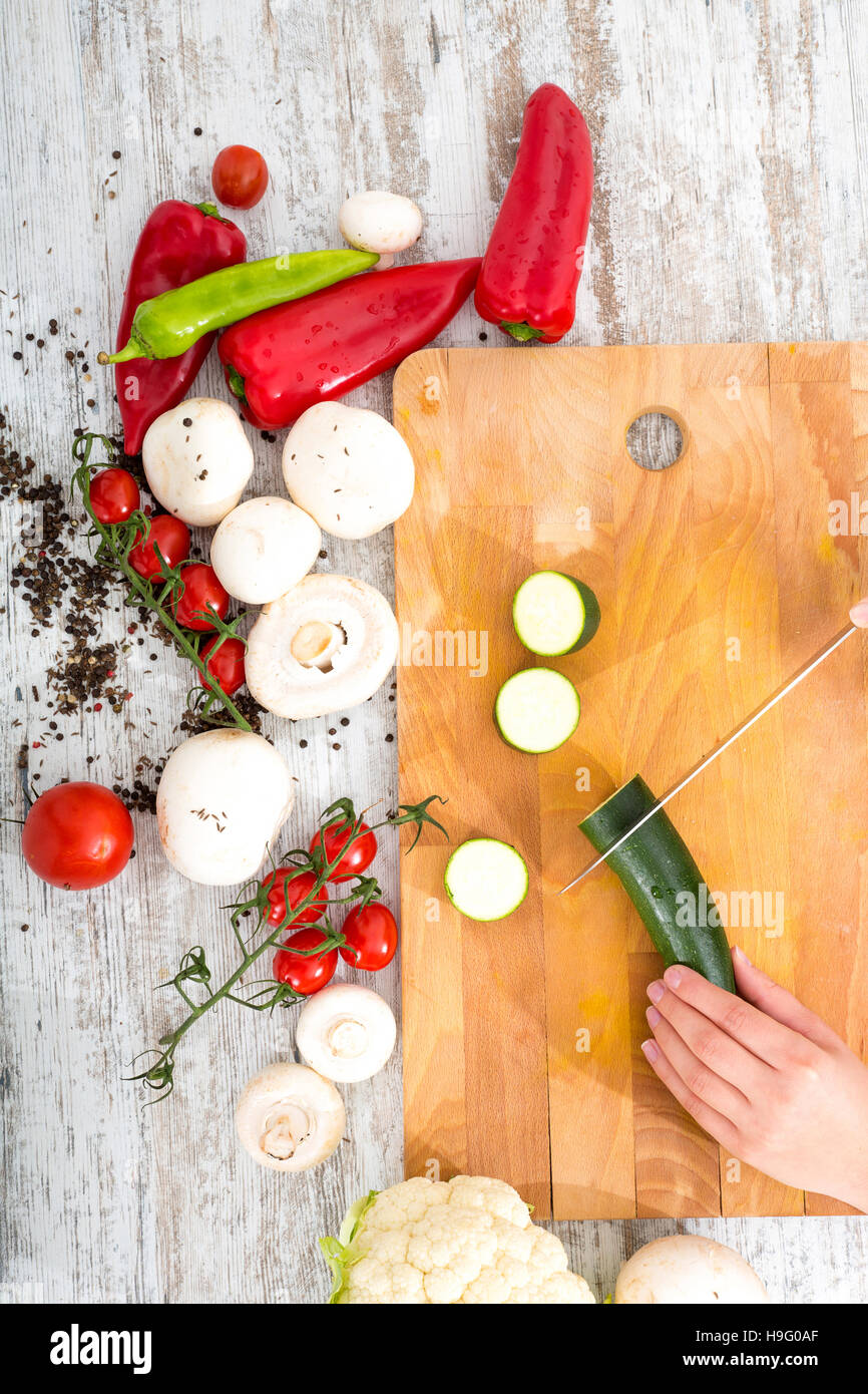 A woman chopping up vegetables at a table Stock Photo - Alamy