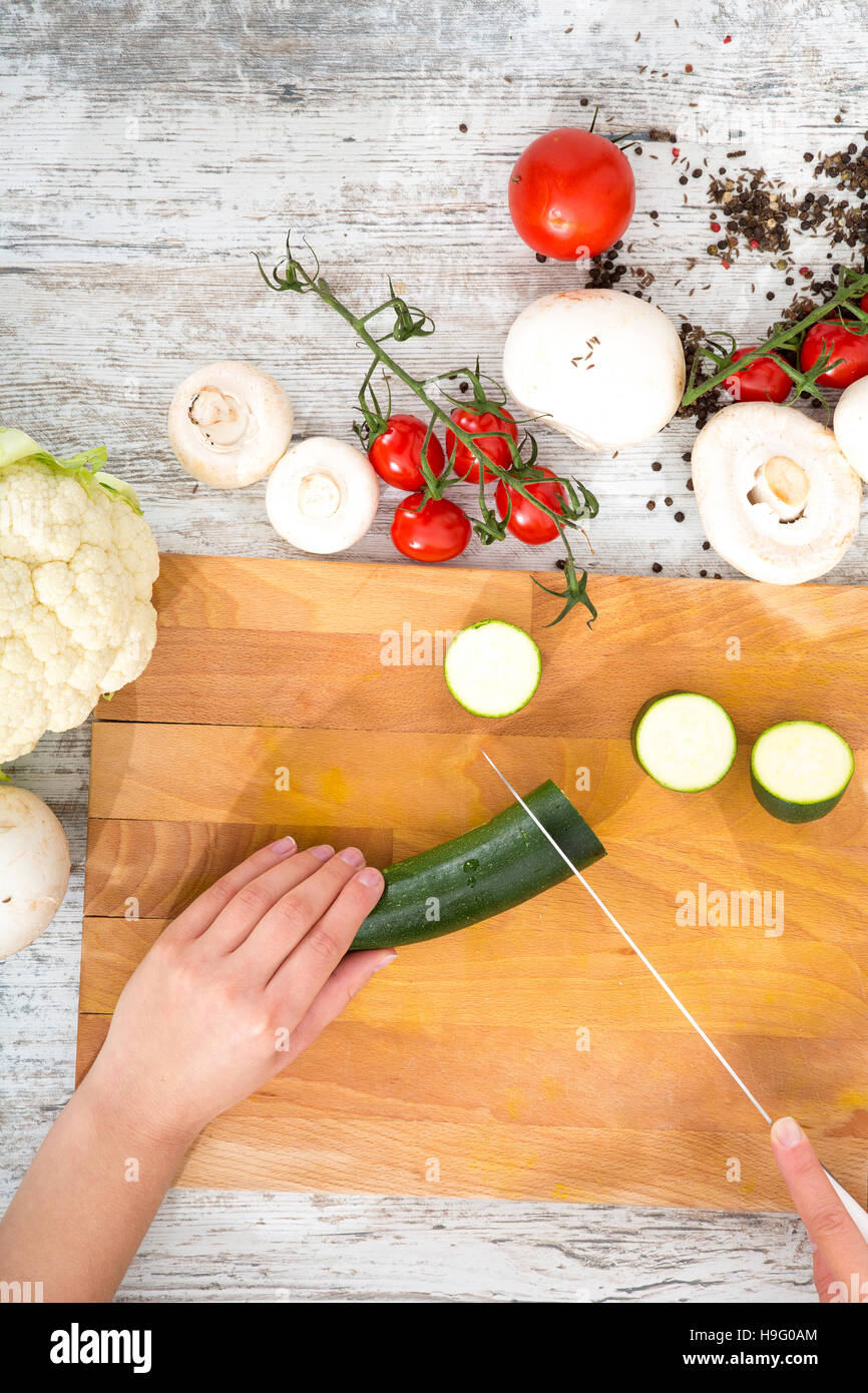 A woman chopping up vegetables at a table Stock Photo - Alamy