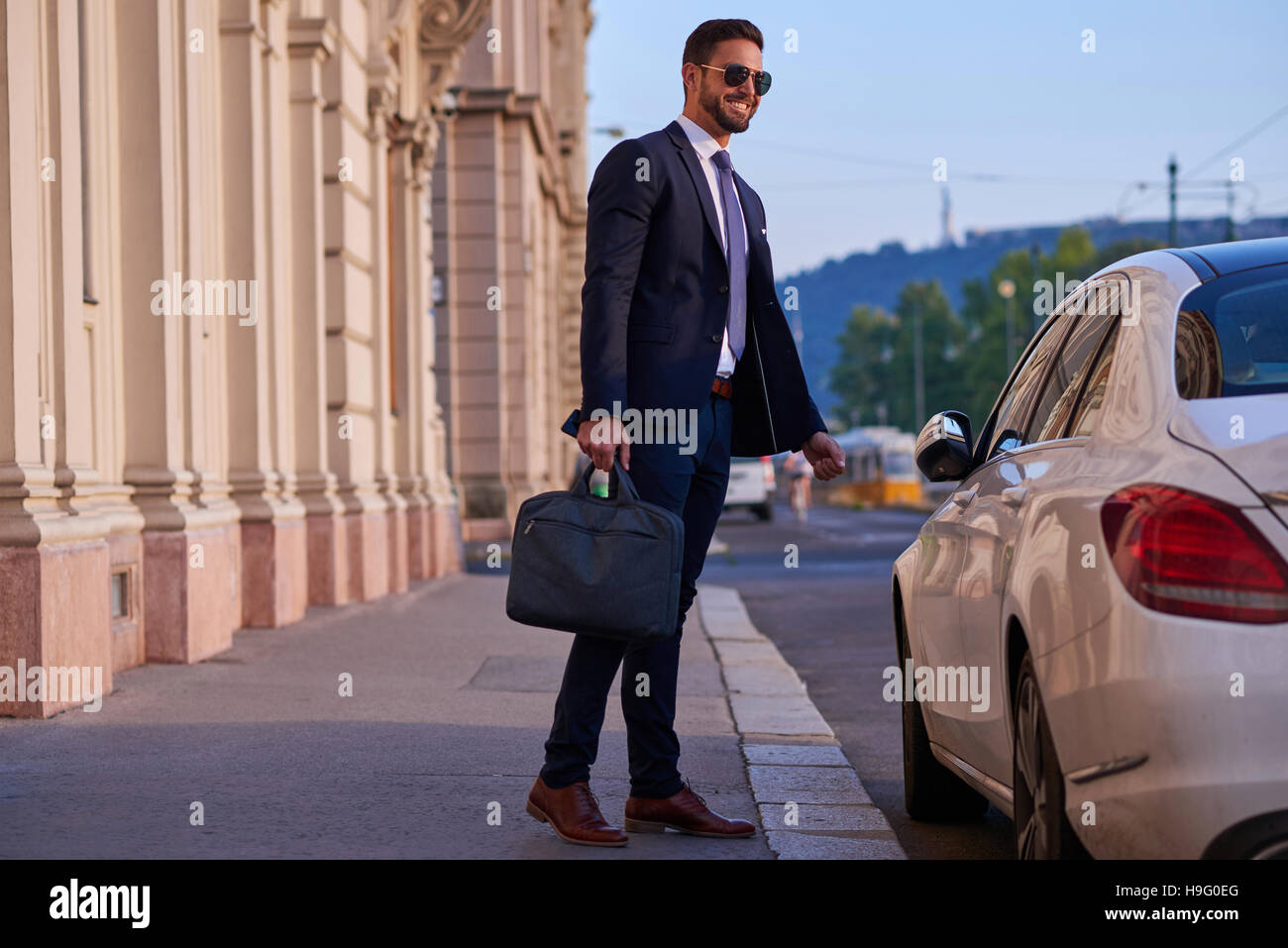 A handsome young businessman walking to his car Stock Photo - Alamy