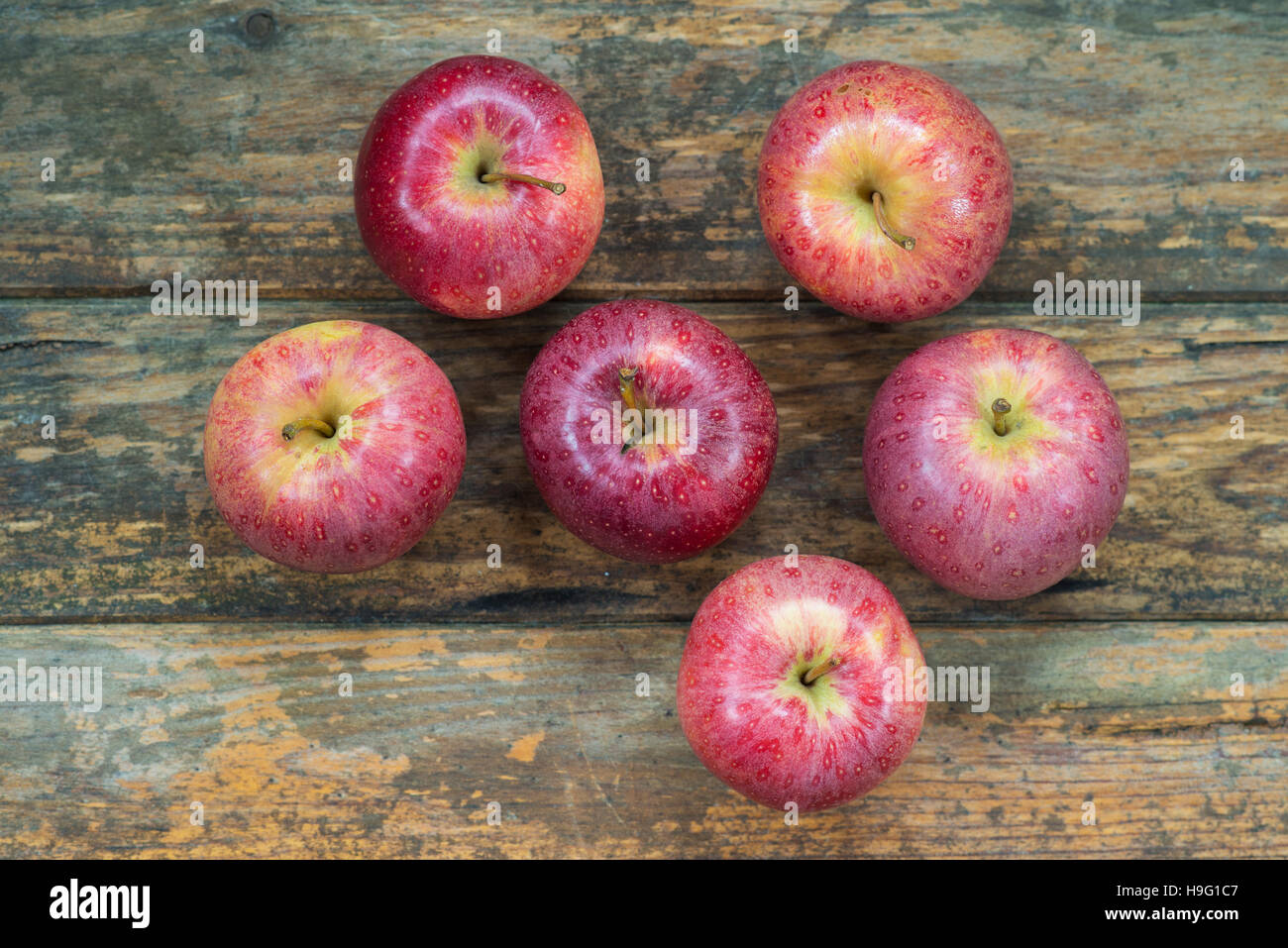 Six red apples on rustic wood Stock Photo - Alamy