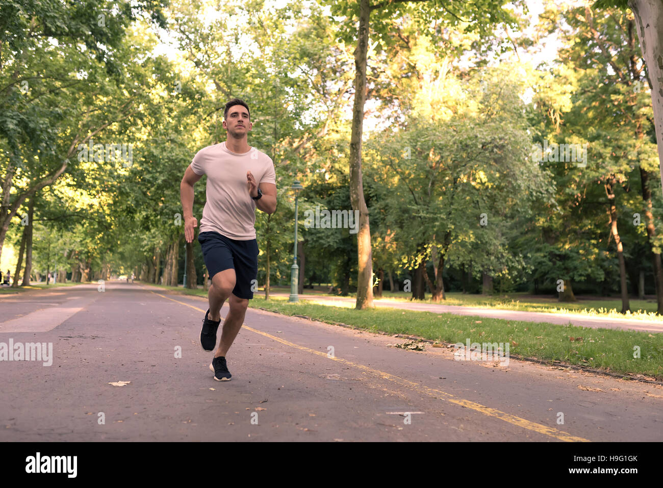 A handsome young man doing sports and jogging in a park Stock Photo - Alamy