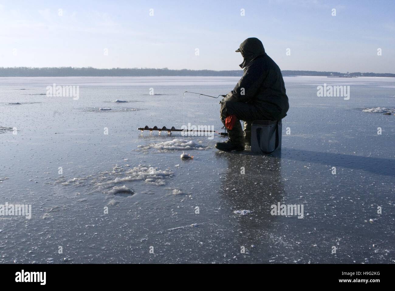 Ice fishing on the frozen lake Stock Photo - Alamy