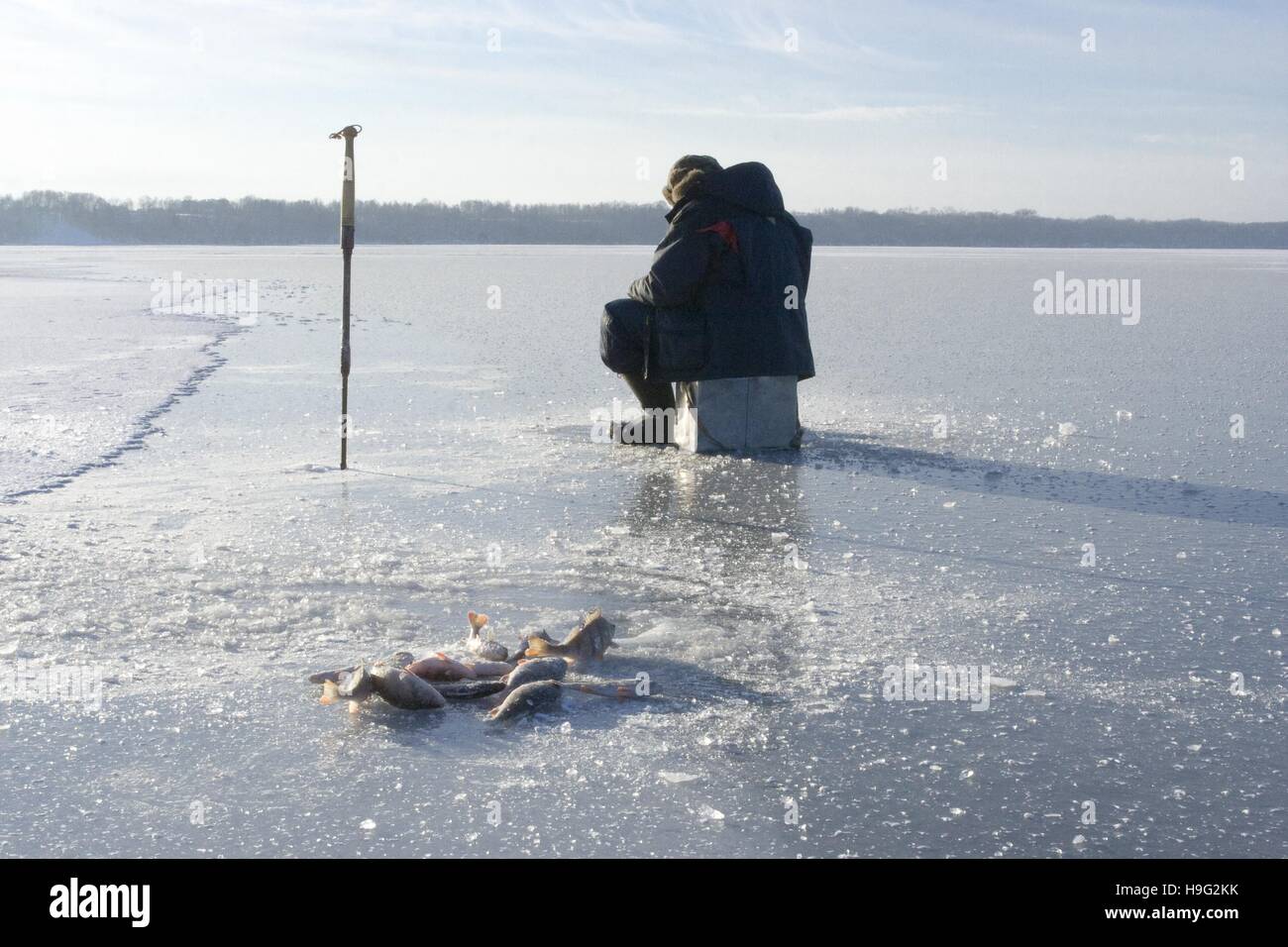 Ice fishing on the frozen lake Stock Photo - Alamy