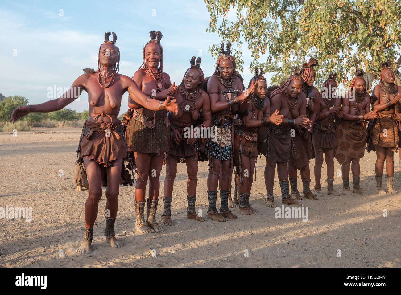Women from Himba people in traditional clothes and haircuts are ...
