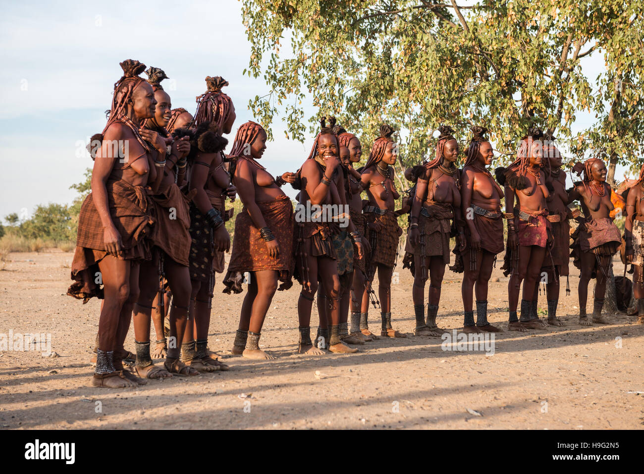 Women from Himba people in traditional clothes and haircuts are ...