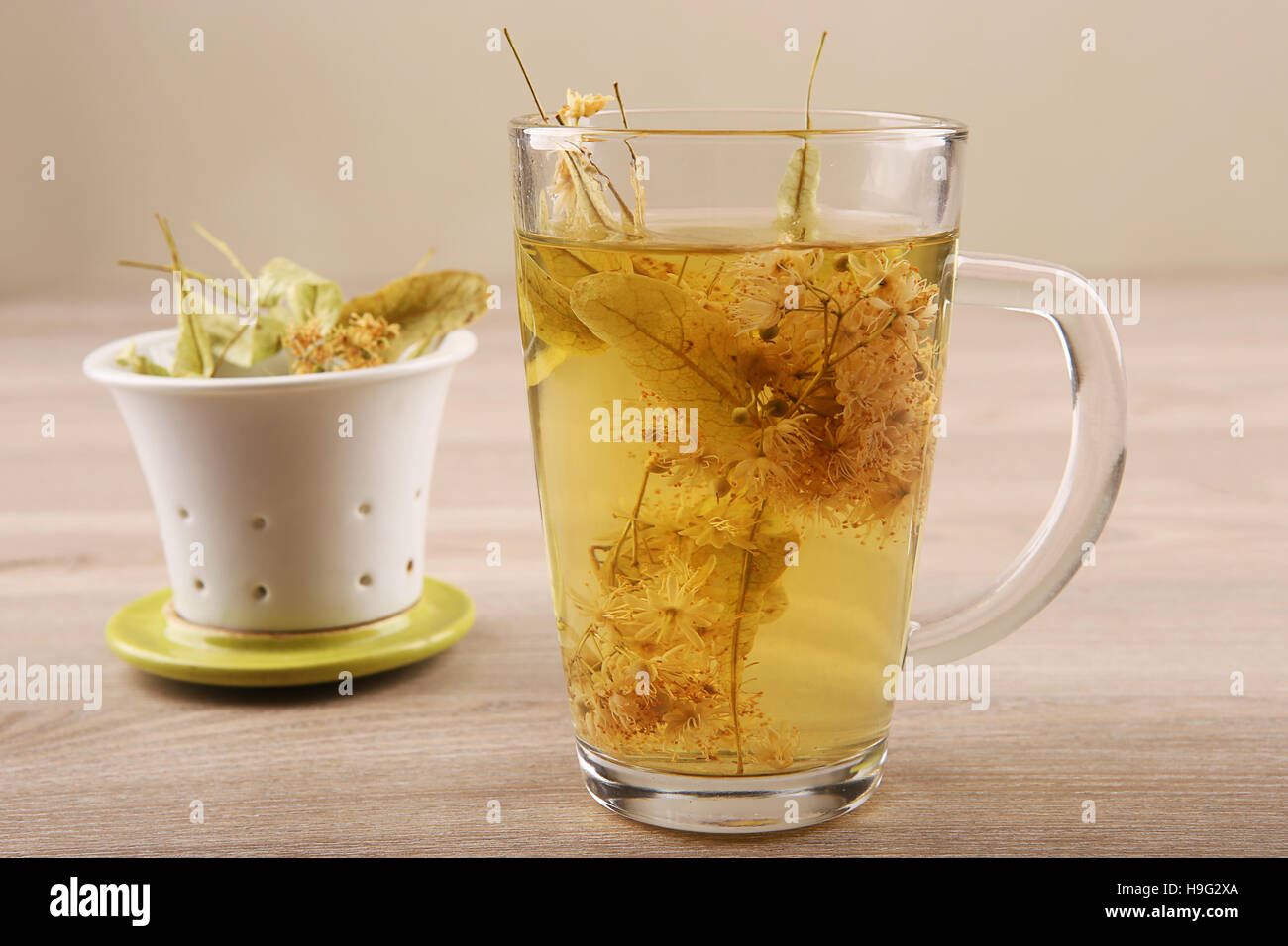 Lime tea cup with dried blossom. Glass cup of tea with herbal linden ...